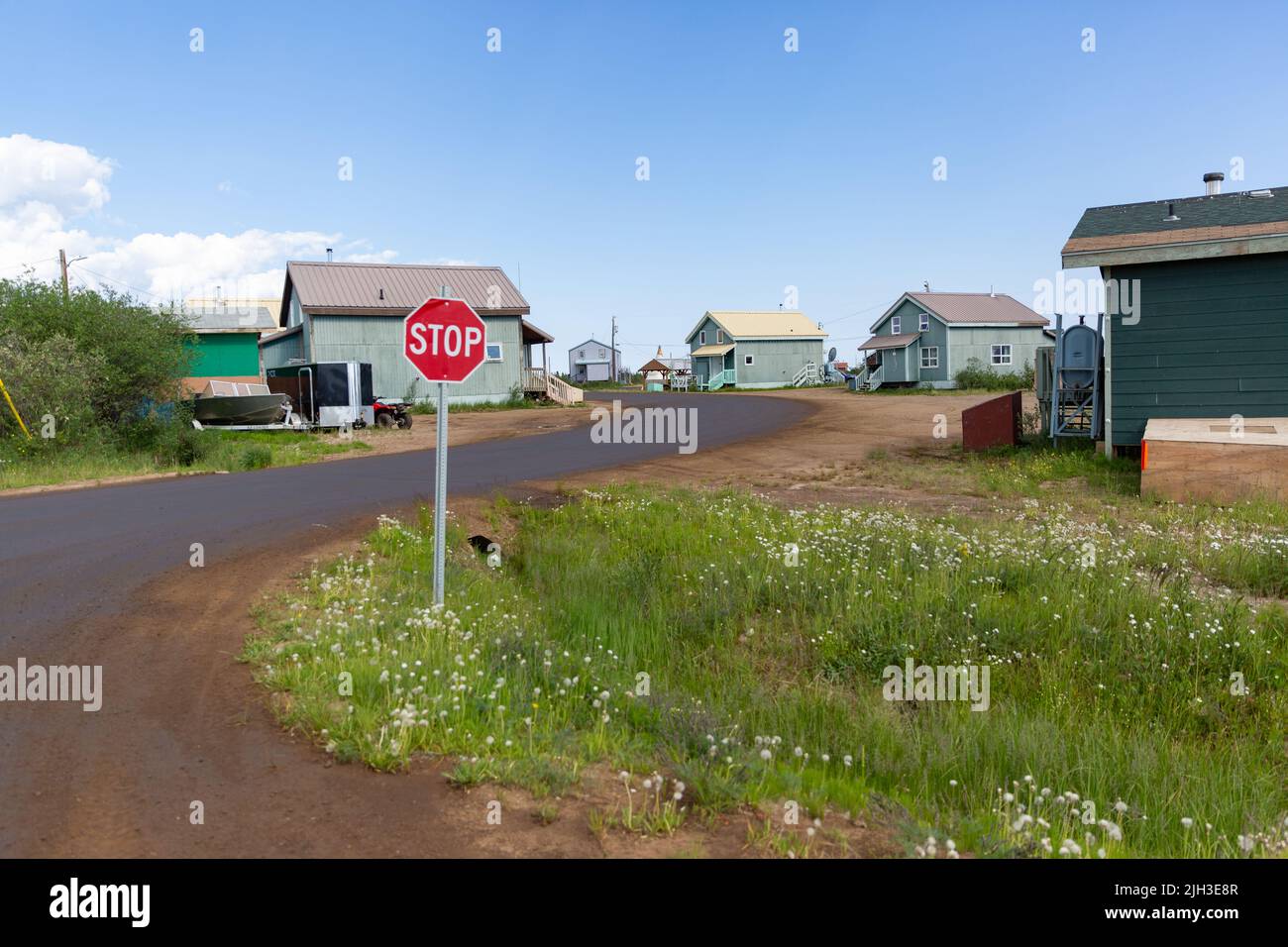 Stop sign and houses along dirt road of the northern Indigenous ...