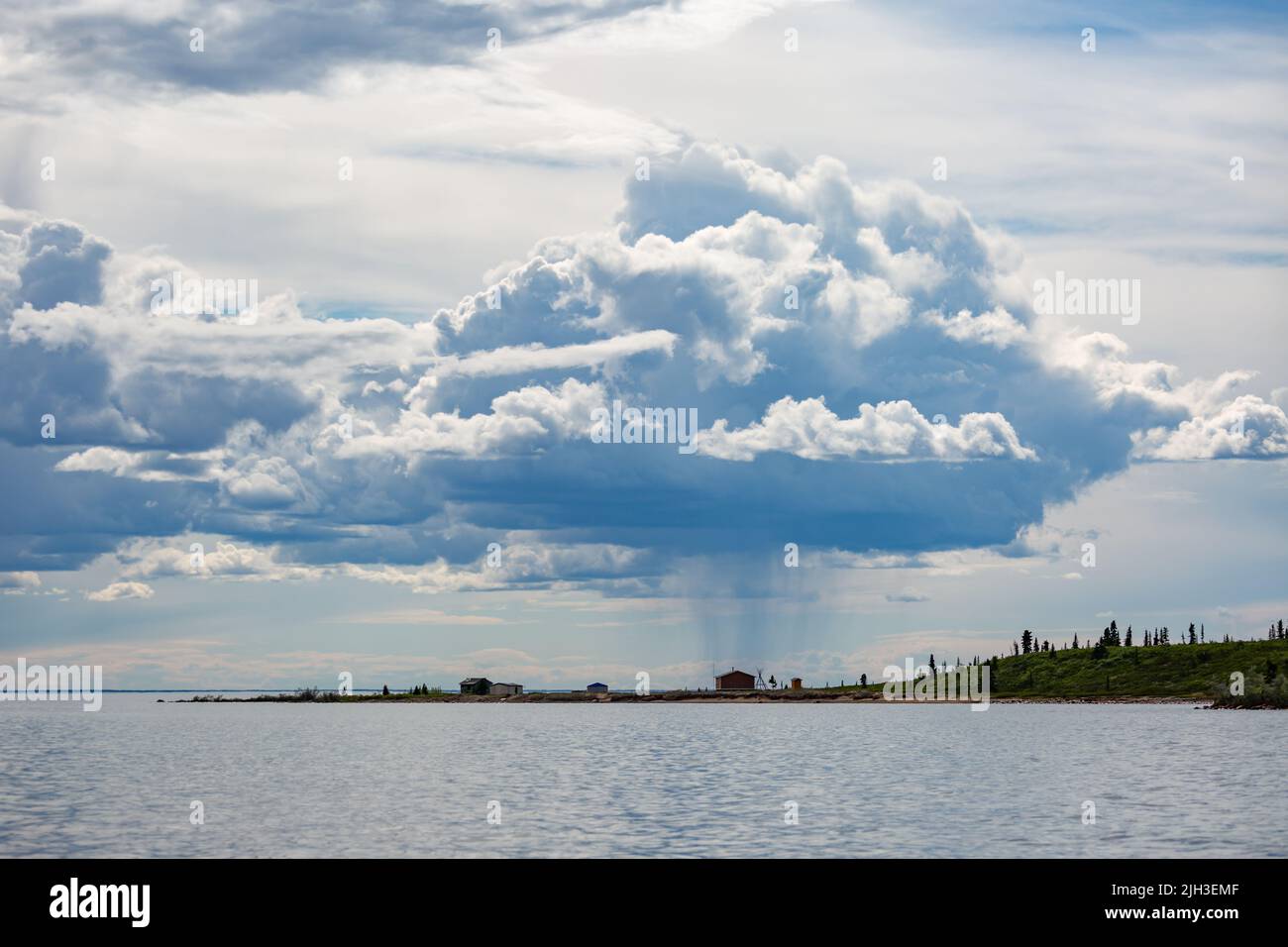 Cumulus cloud above small cabin along Great Bear Lake in the summer ...