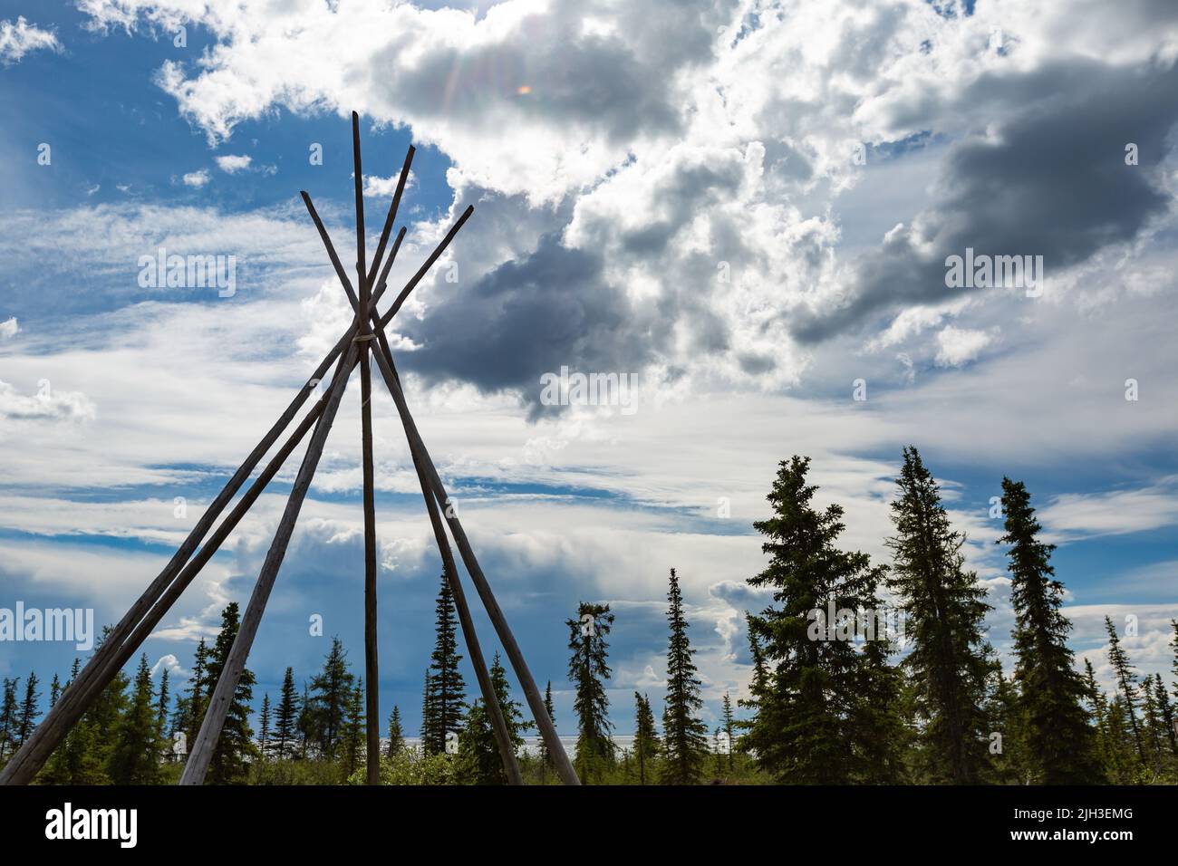Wooden poles of traditional teepee at cabin in summer, near the ...