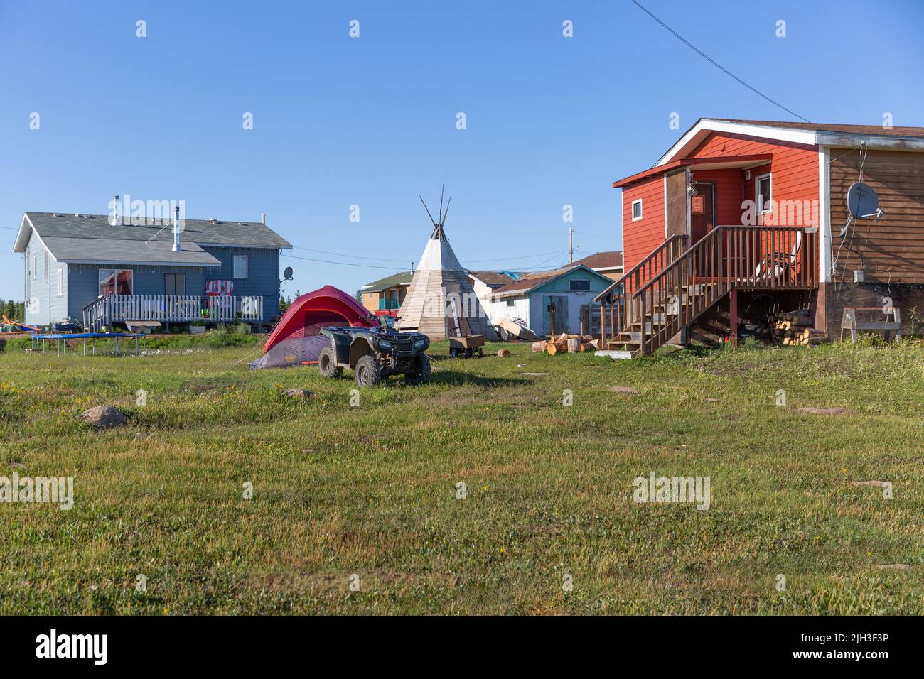House with teepee in yard during summer, in the northern Indigenous ...