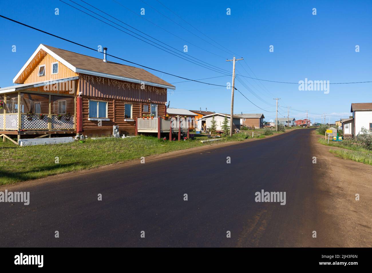 House along dirt road in summer, in the northern Indigenous community ...