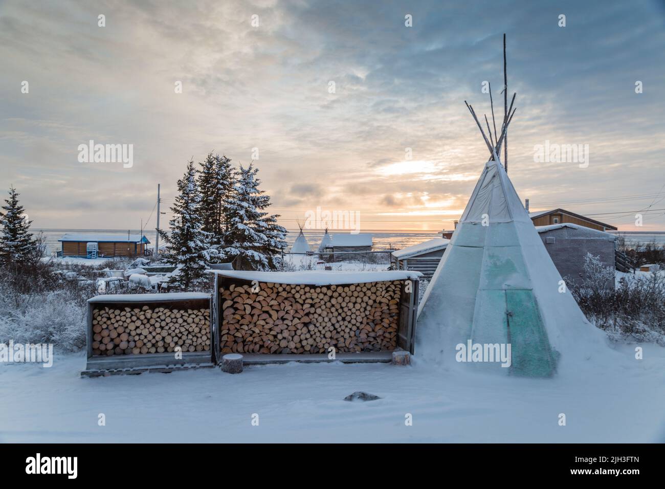 Traditional teepee and woodpile in winter, in the northern Indigenous ...