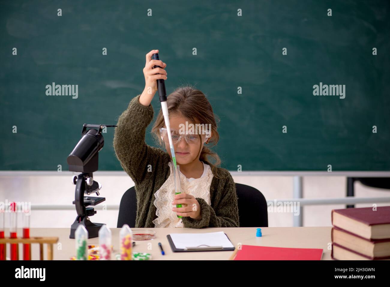 Young small girl chemist in the classroom Stock Photo - Alamy