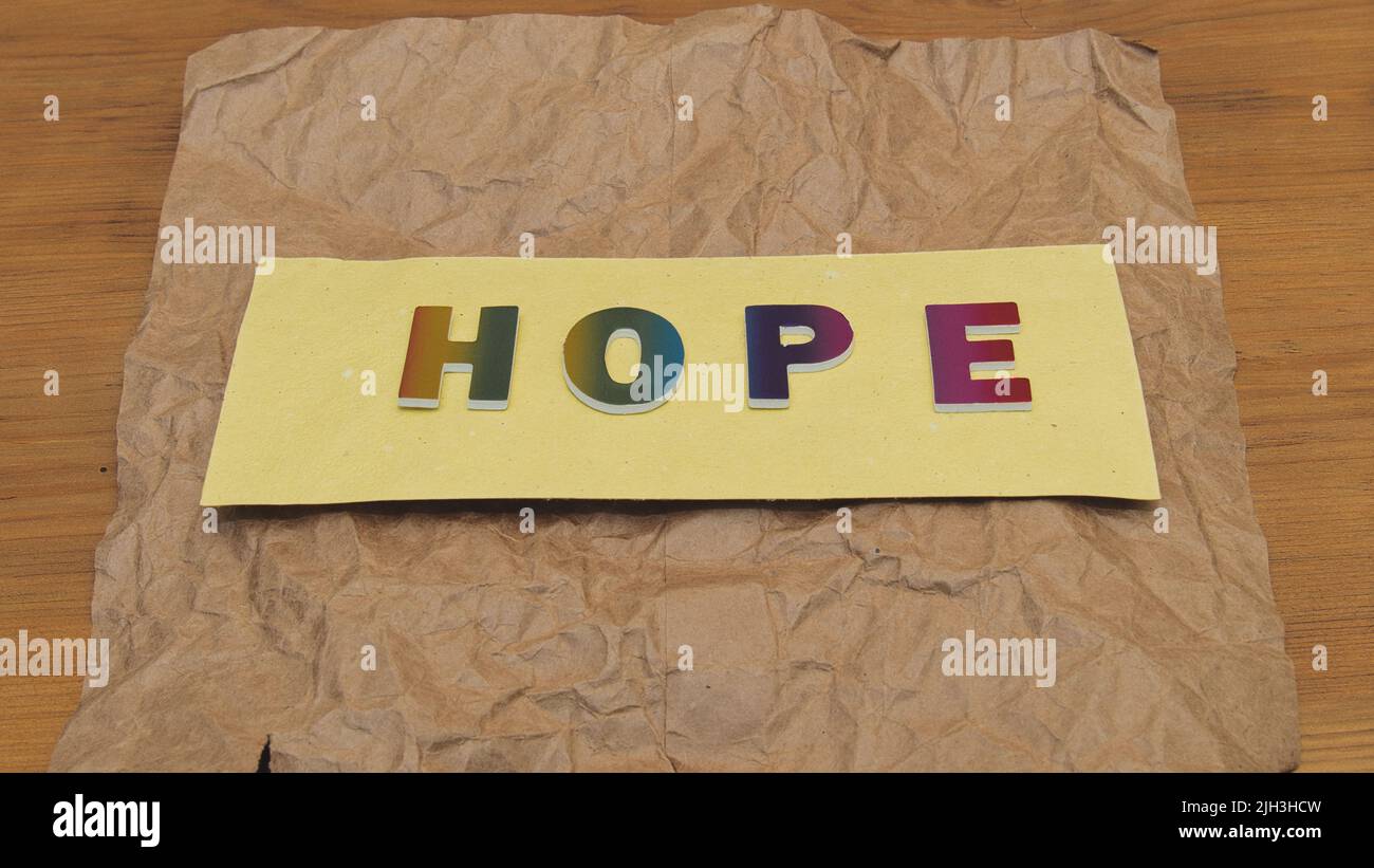 The word "HOPE" in rainbow lettering on brown paper background Stock ...