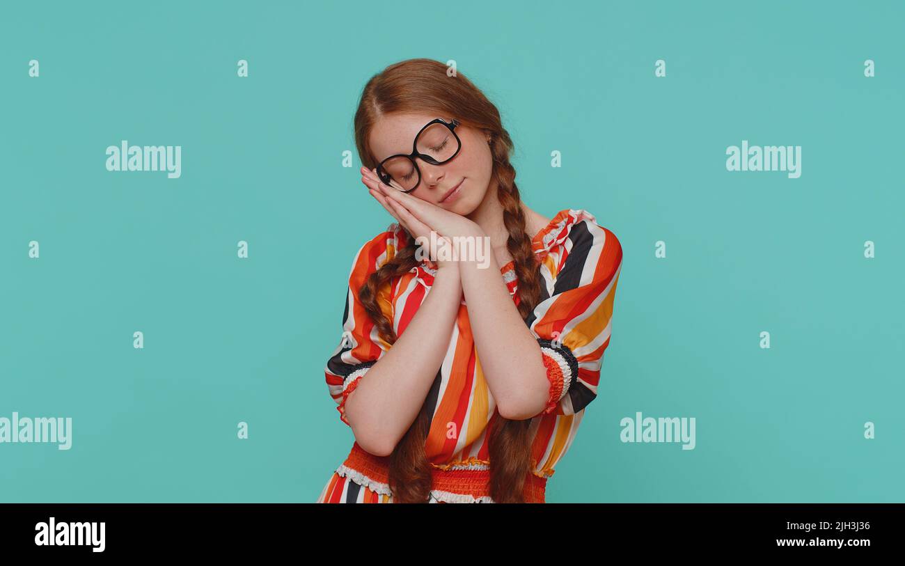 Tired redhead girl going to sleep laying down on his palms, yawning ...