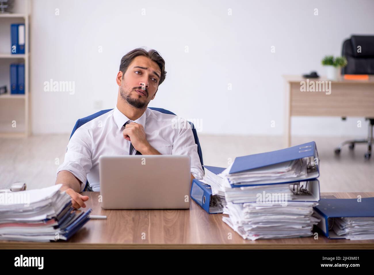 Young businessman employee and too much work in the office Stock Photo ...