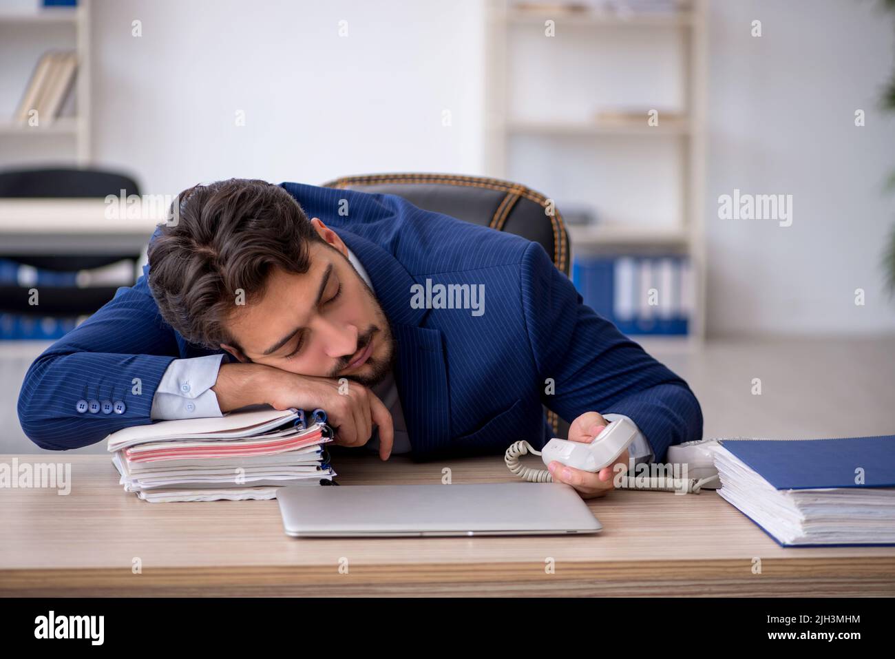 Young businessman employee extremely tired at workplace Stock Photo - Alamy