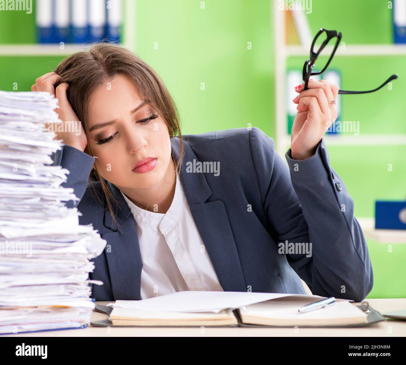 The young female employee very busy with ongoing paperwork Stock Photo ...