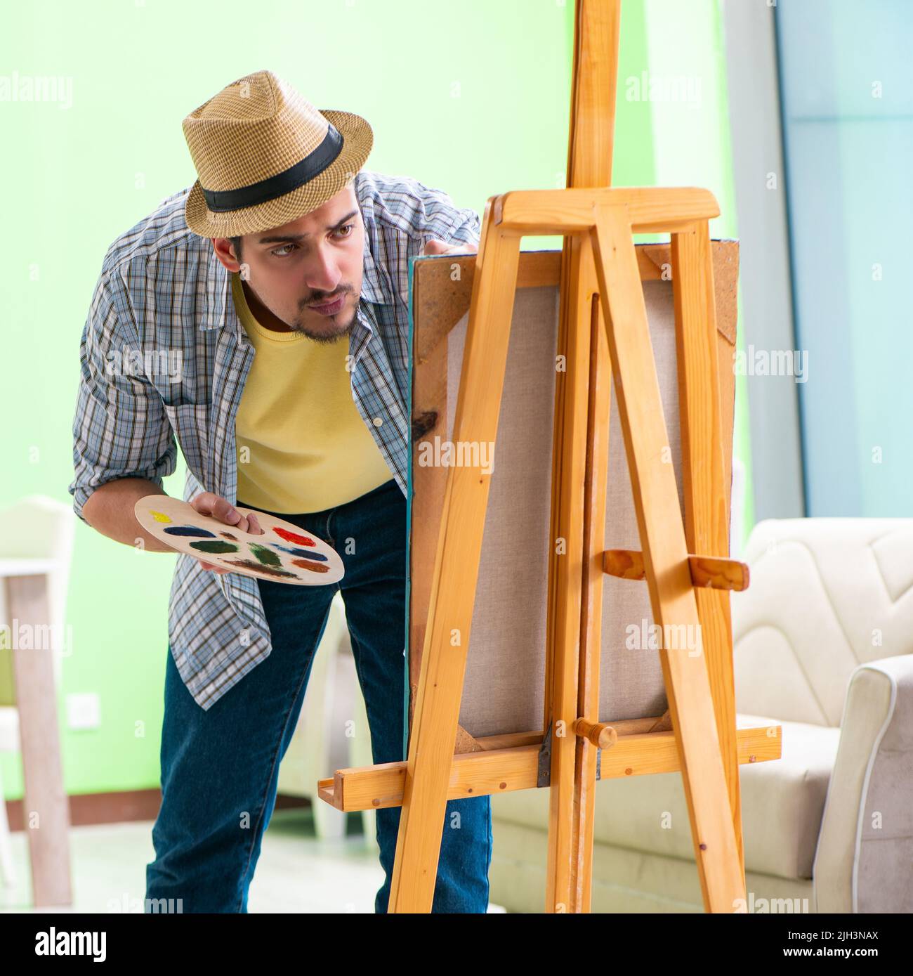 The young male artist working on new painting in his studio Stock Photo ...