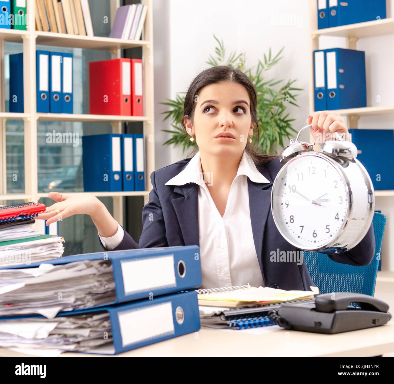 Female employee with too much work in the office Stock Photo - Alamy