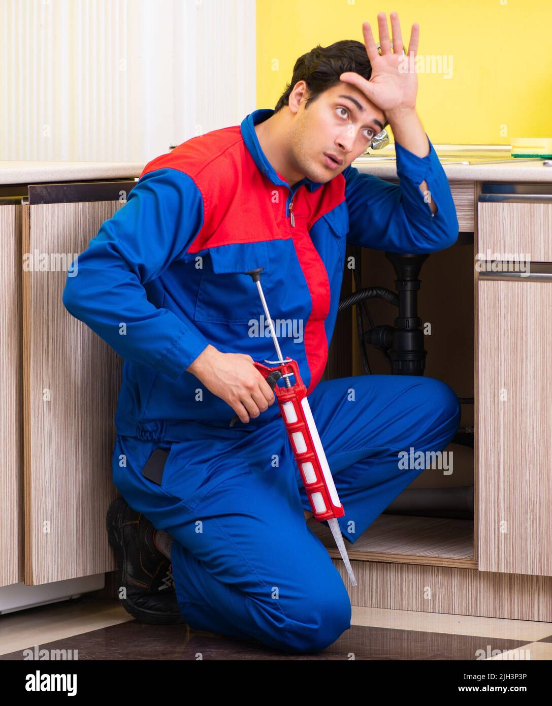 The plumber repairing wash basin at kitchen Stock Photo - Alamy