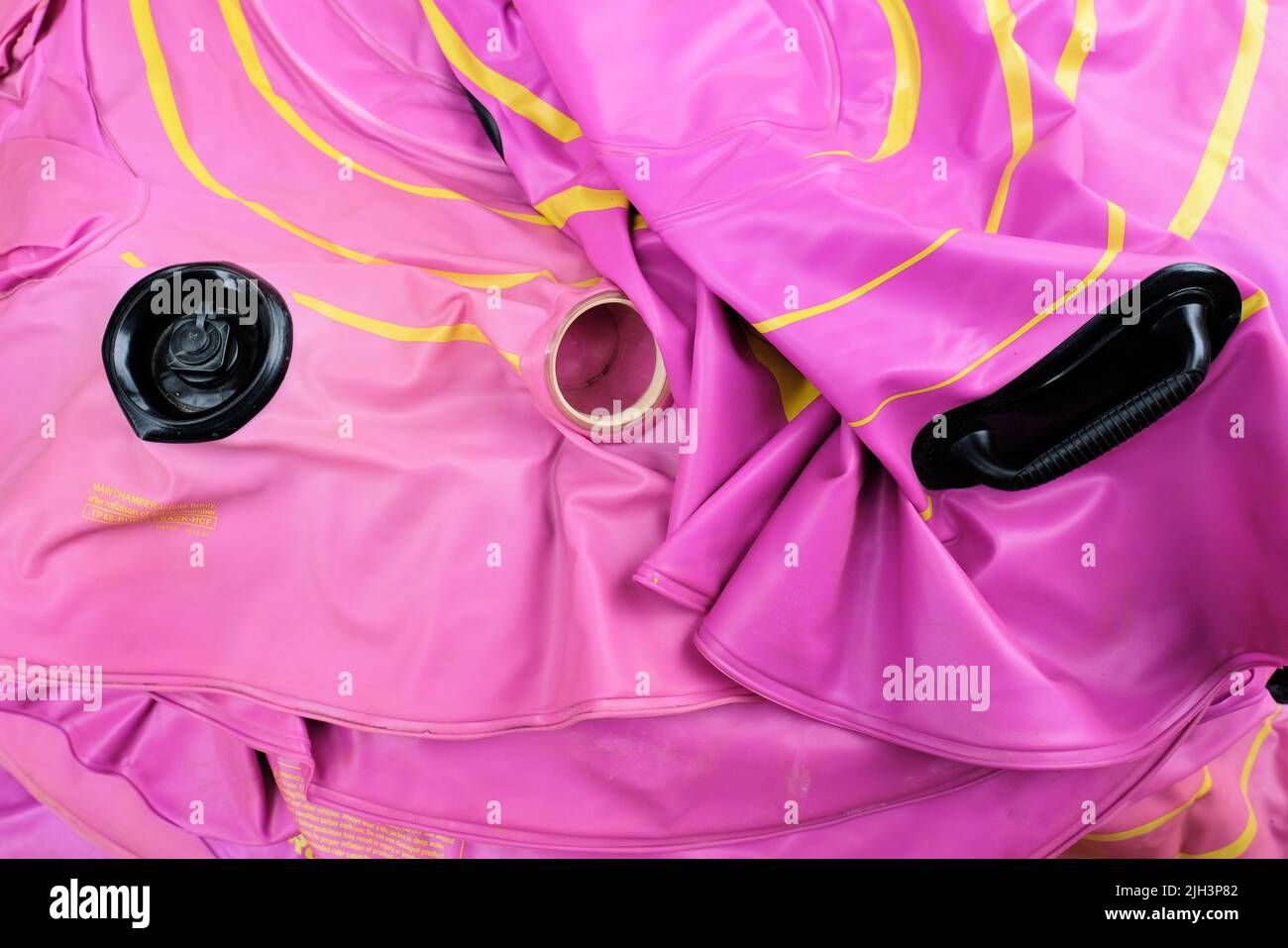 Deflated pink one-person river tube floatation device used for floating ...