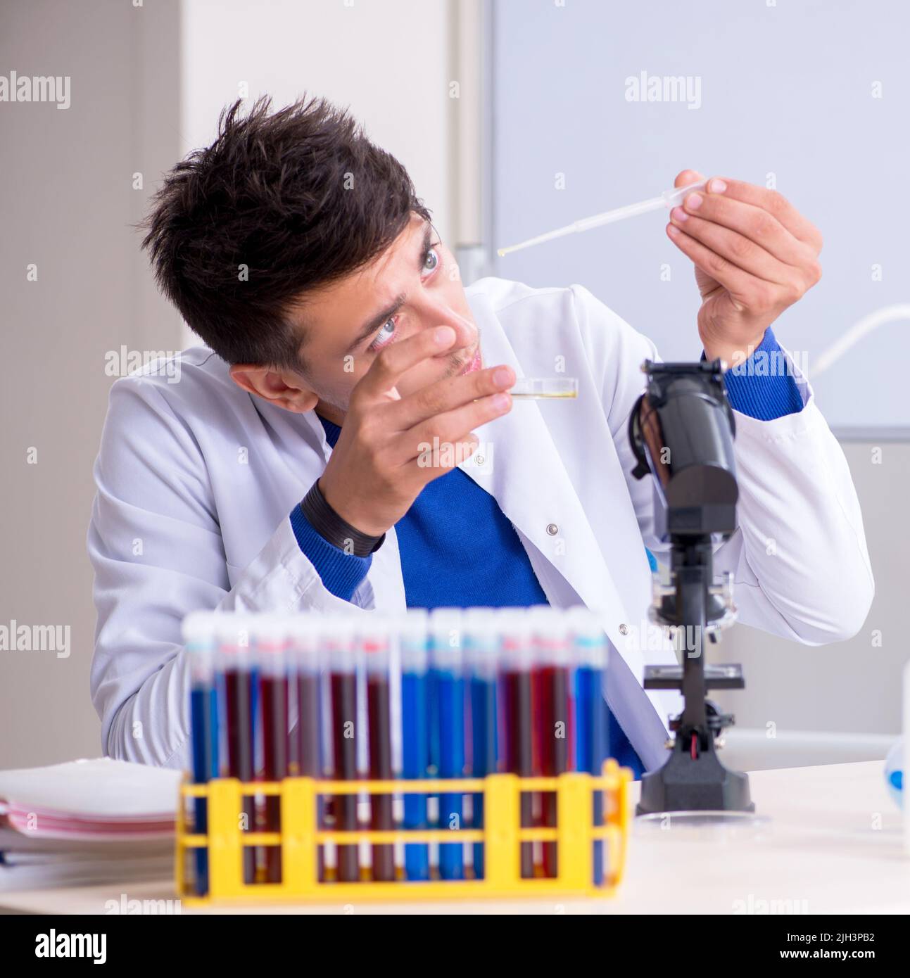 Young chemist sitting in the lab Stock Photo - Alamy