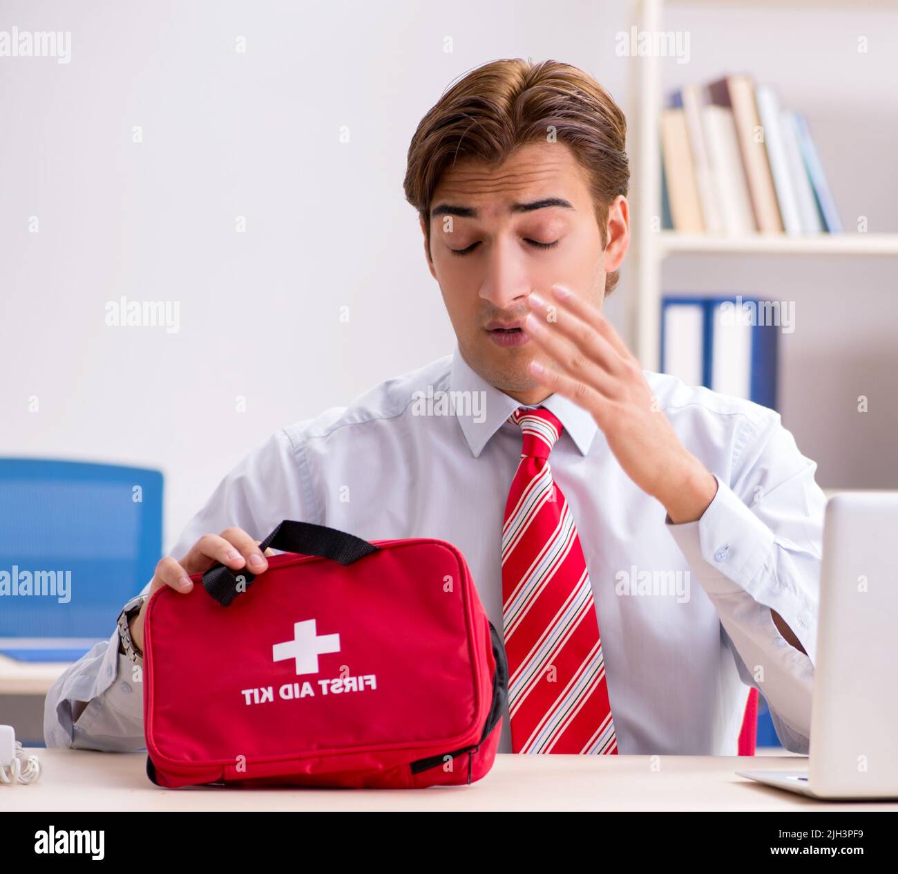 Man with first aid kit in the office Stock Photo - Alamy