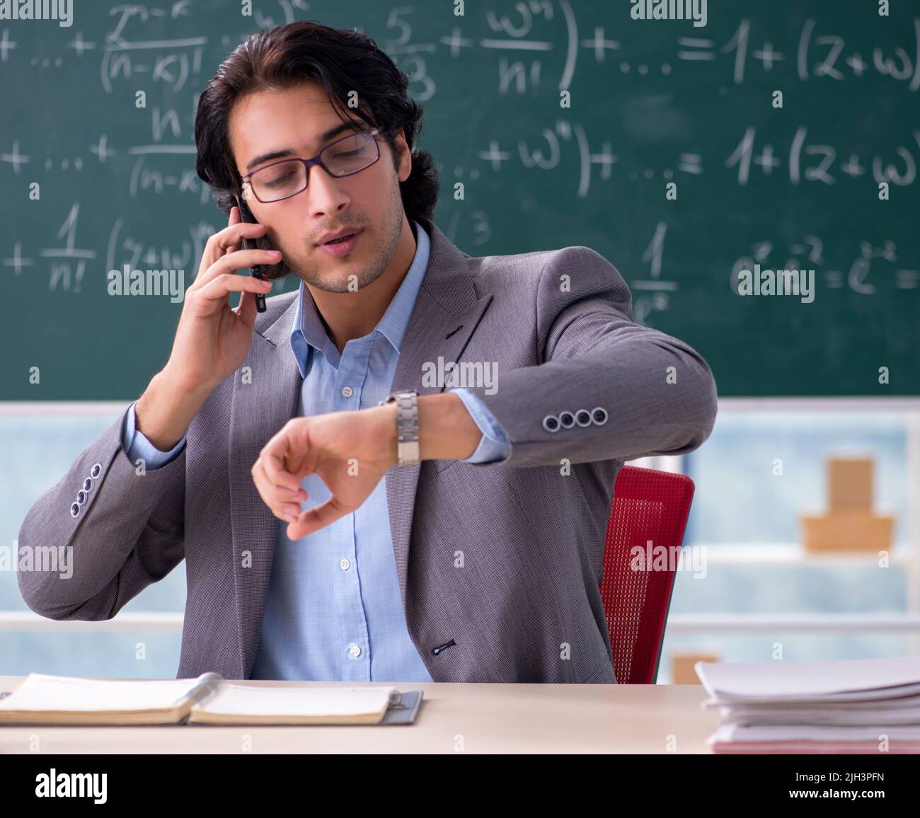 Young handsome math teacher in classroom Stock Photo - Alamy
