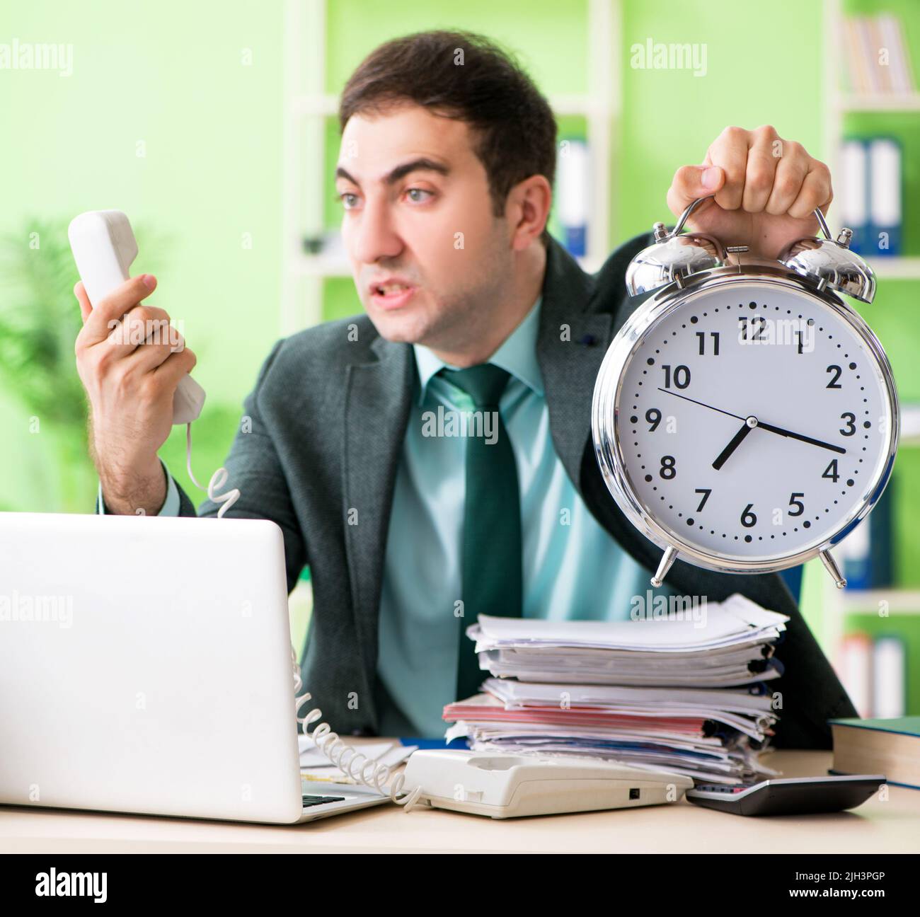 Businessman angry with excessive work sitting in the office in time ...