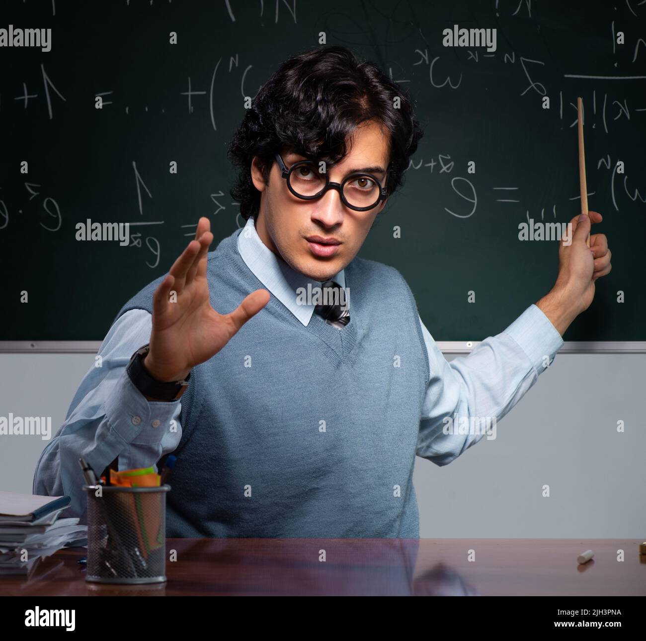 Young math teacher in front of chalkboard Stock Photo - Alamy