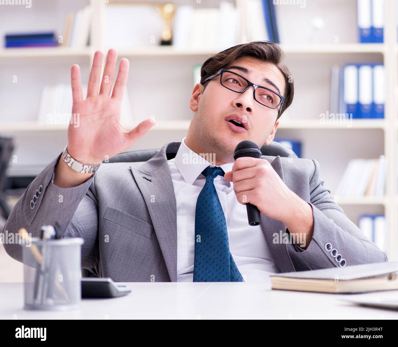 The businessman singing in the office Stock Photo - Alamy