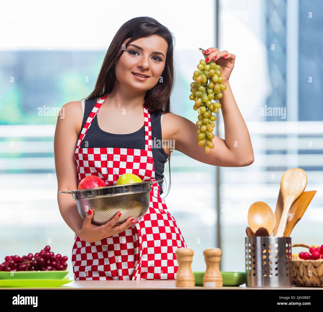 The young cook with fruits in the kitchen Stock Photo - Alamy