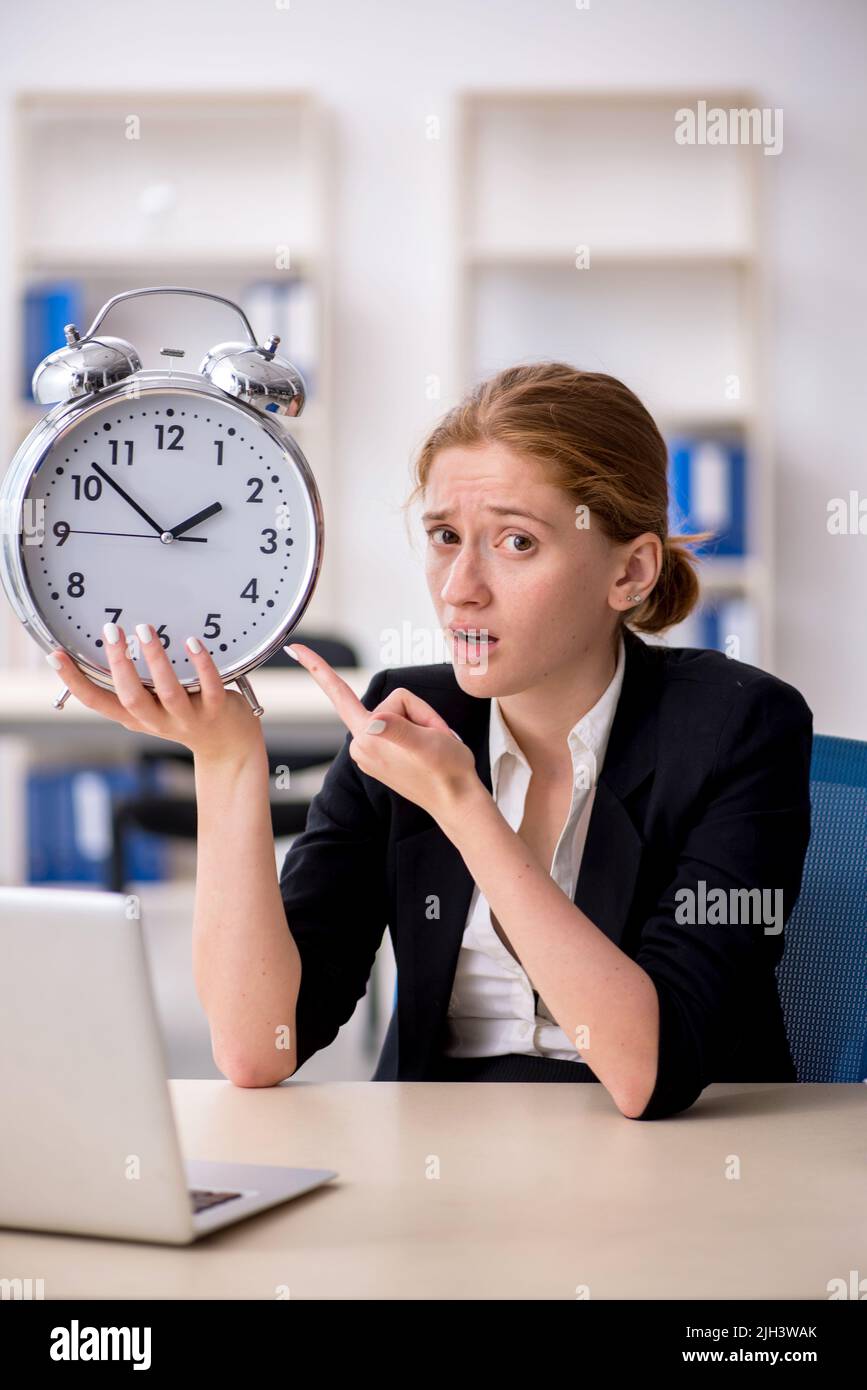 Female employee in time management concept Stock Photo - Alamy