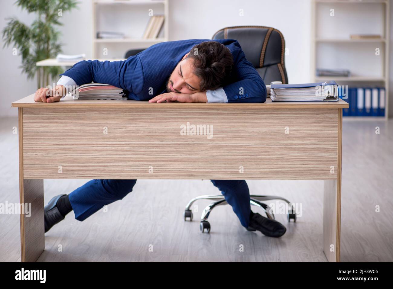 Young businessman employee extremely tired at workplace Stock Photo - Alamy
