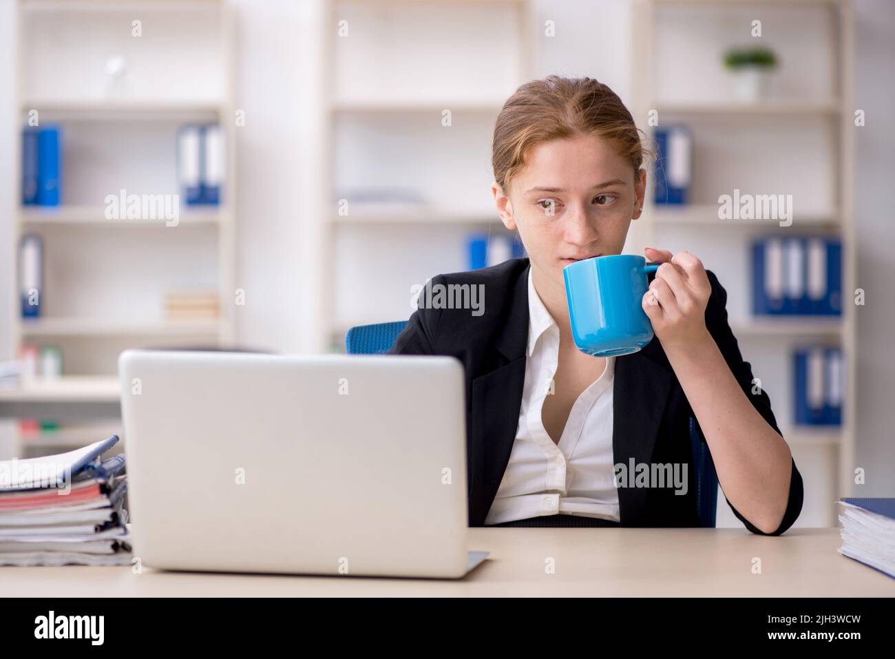 Female employee drinking coffee during break Stock Photo - Alamy