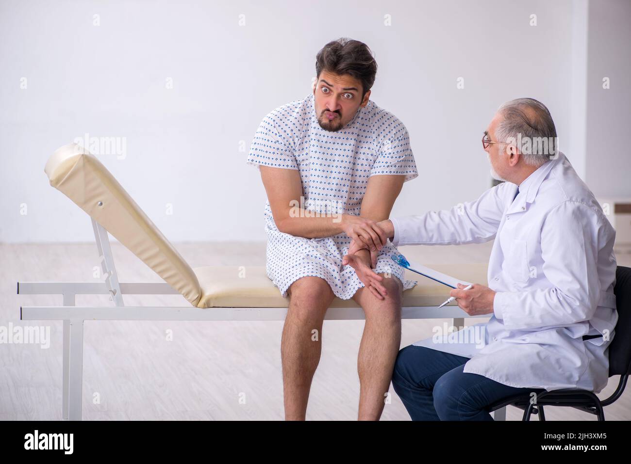Old doctor psychiatrist examining young male patient Stock Photo - Alamy