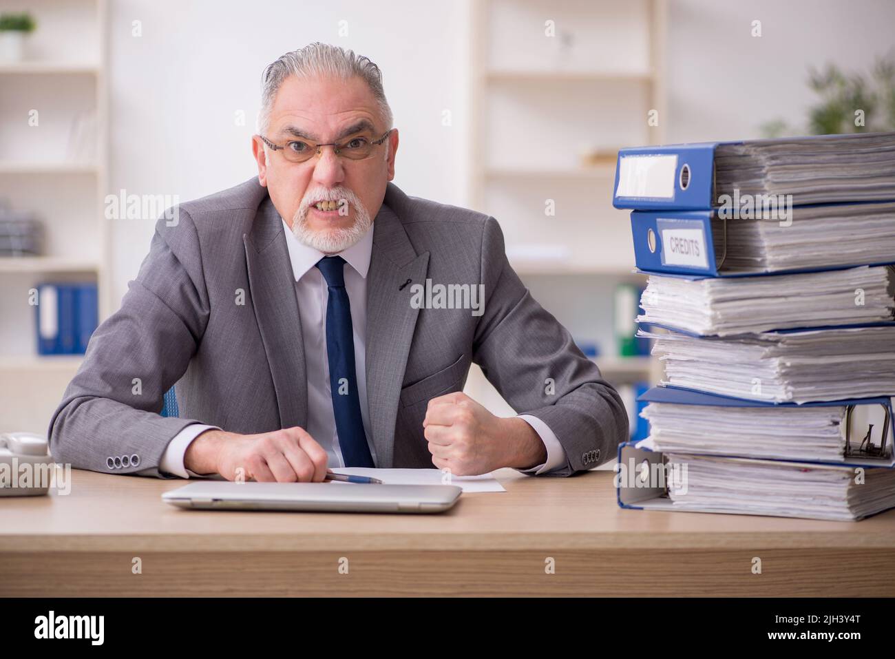 Old businessman employee unhappy with excessive work in the office ...