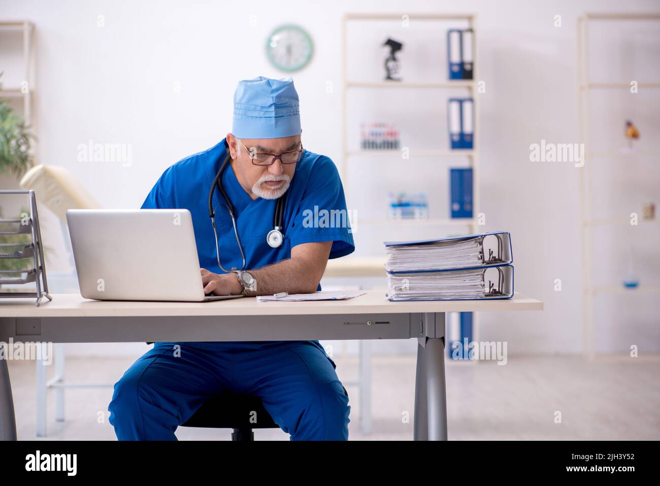 Old doctor working in the clinic Stock Photo - Alamy