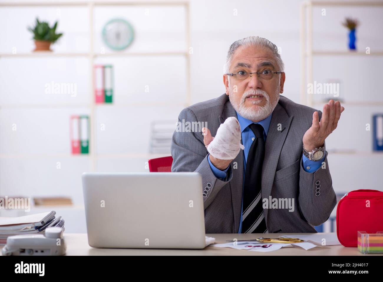 Old businessman employee cutting his hand at workplace Stock Photo - Alamy
