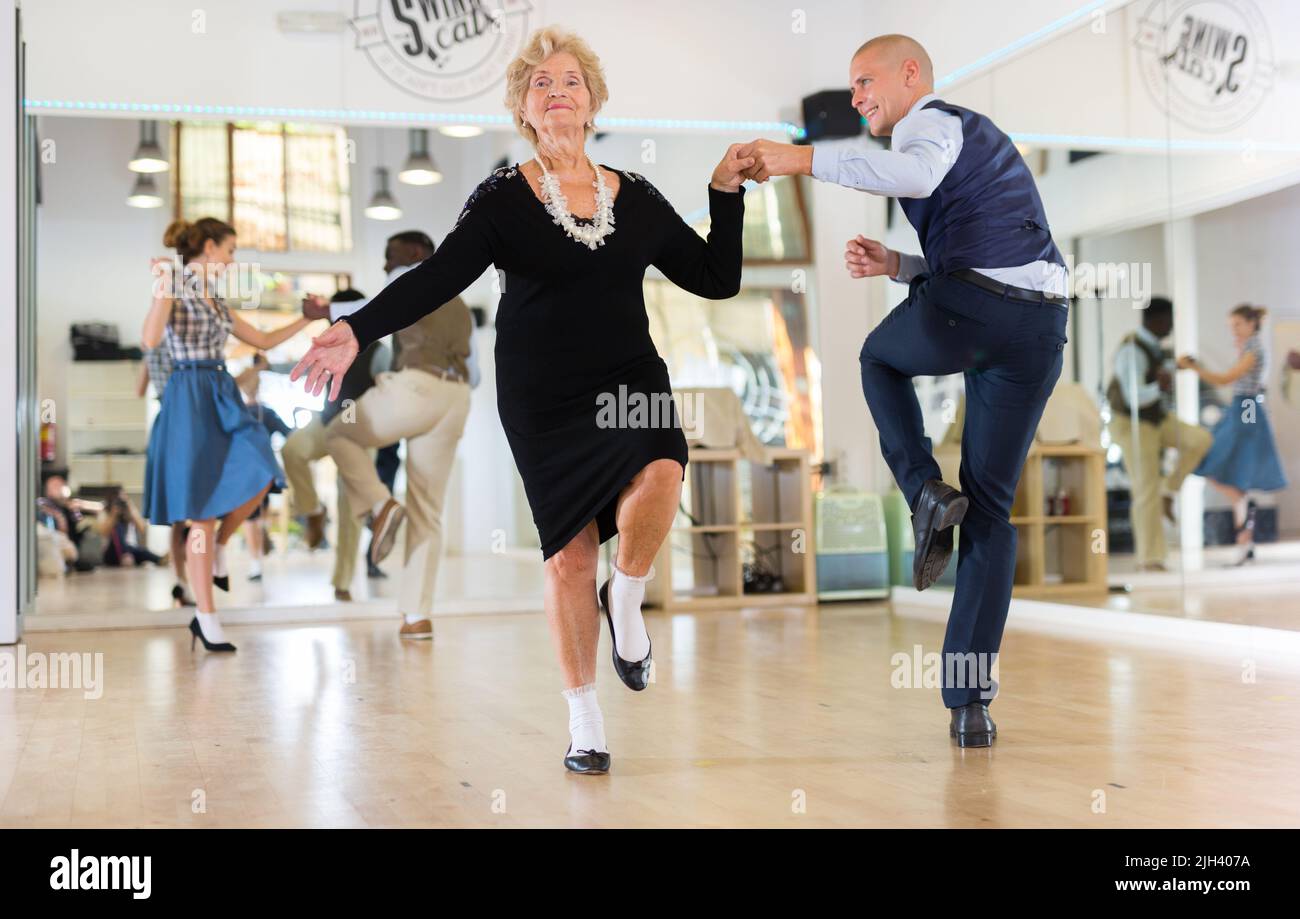 Mature woman dancing swing with young man Stock Photo - Alamy