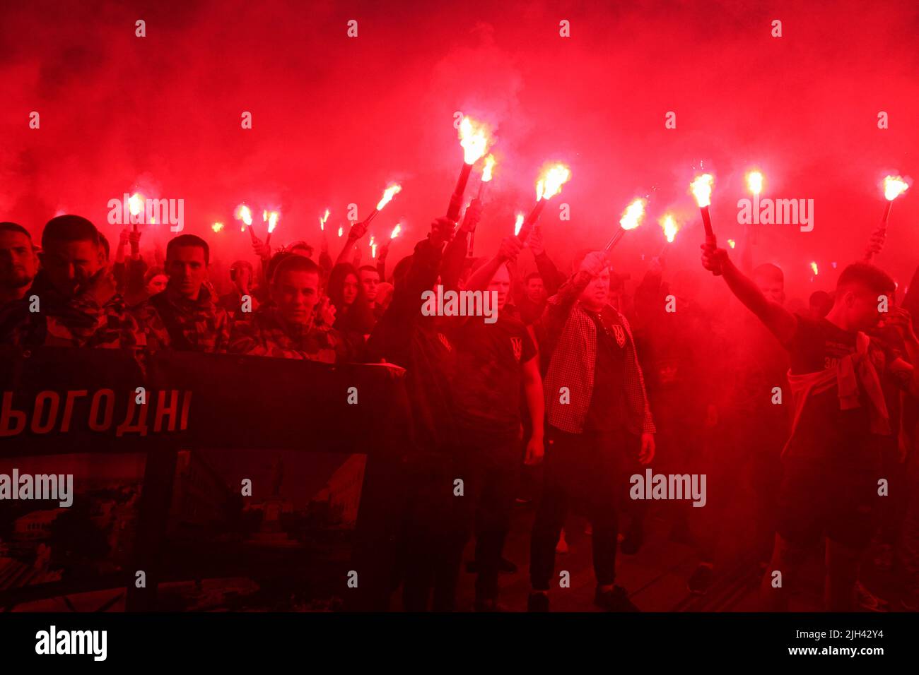 Participants are seen holding burning flares during the procession. The ...