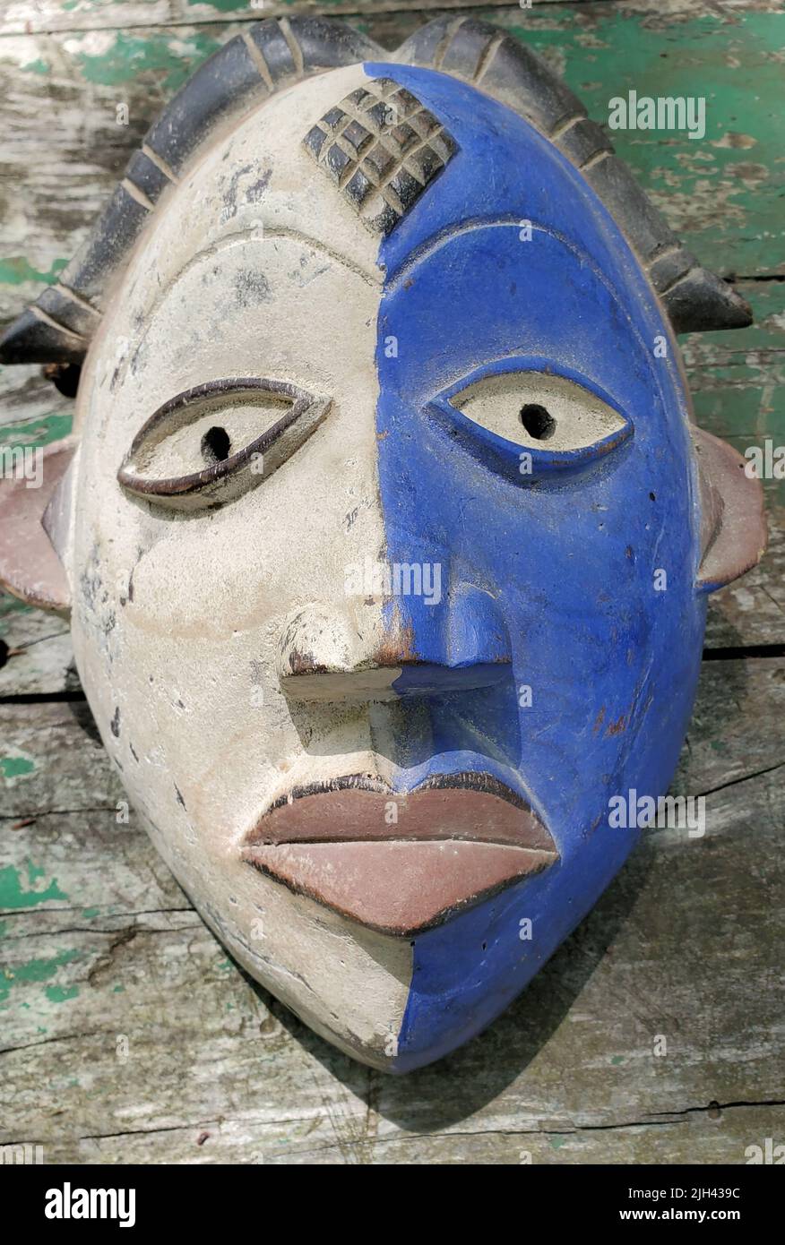 carved african mask painted blue and white Stock Photo - Alamy