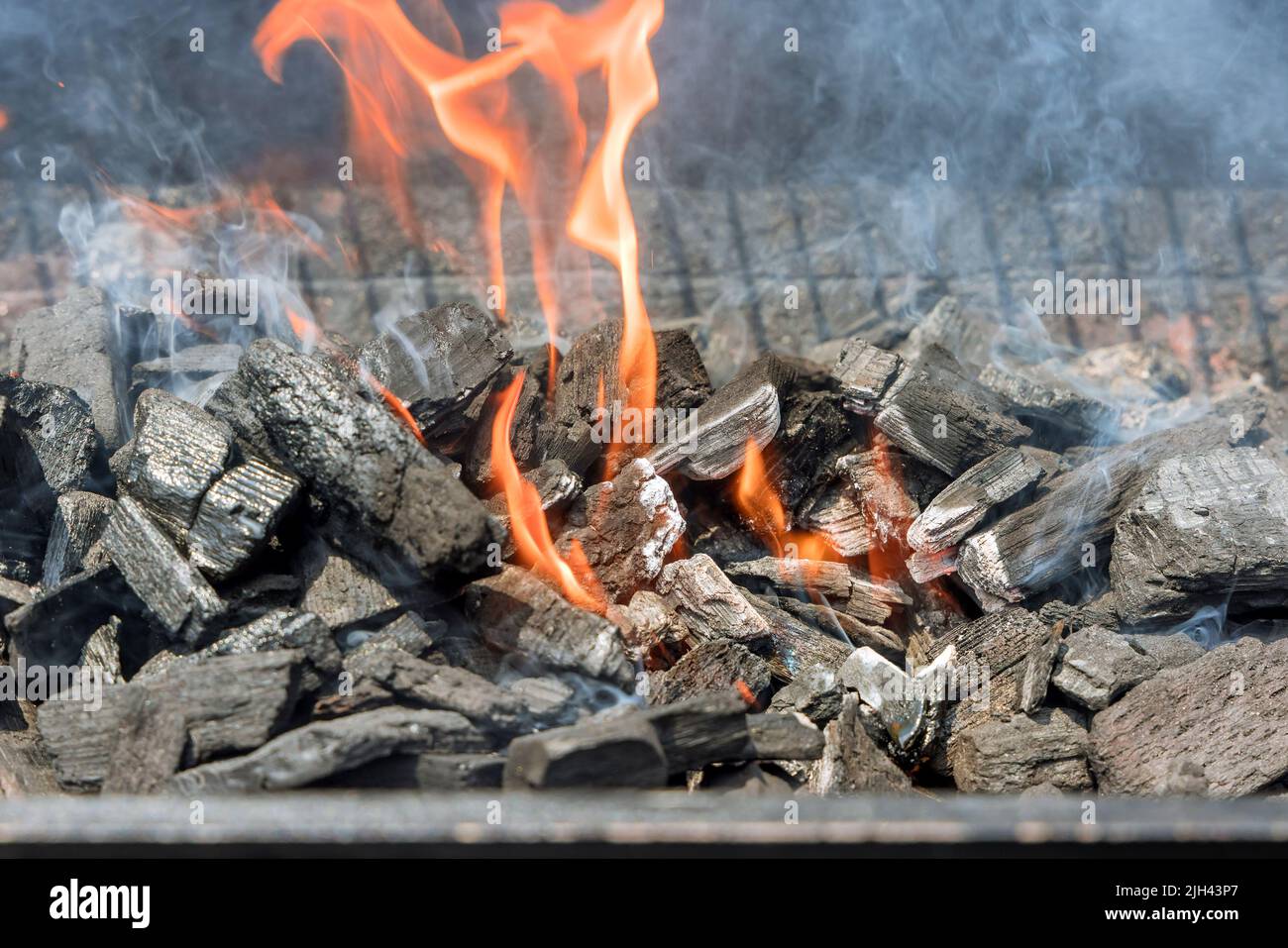 Fire is blazing on the BBQ grill over flaming hot charcoal Stock Photo ...
