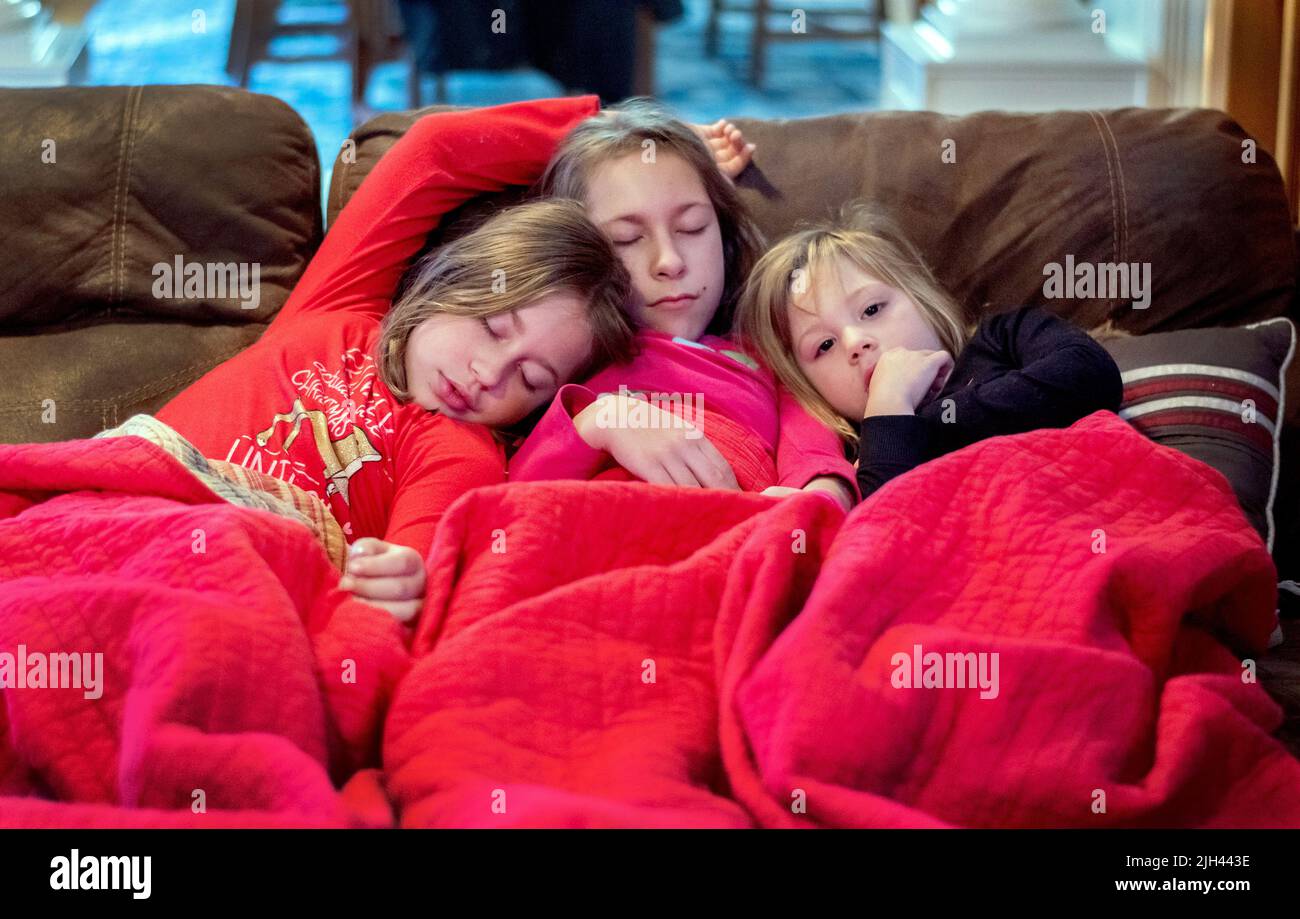 Three sisters snuggle on grandma's sofa, but one girl wakes up early ...