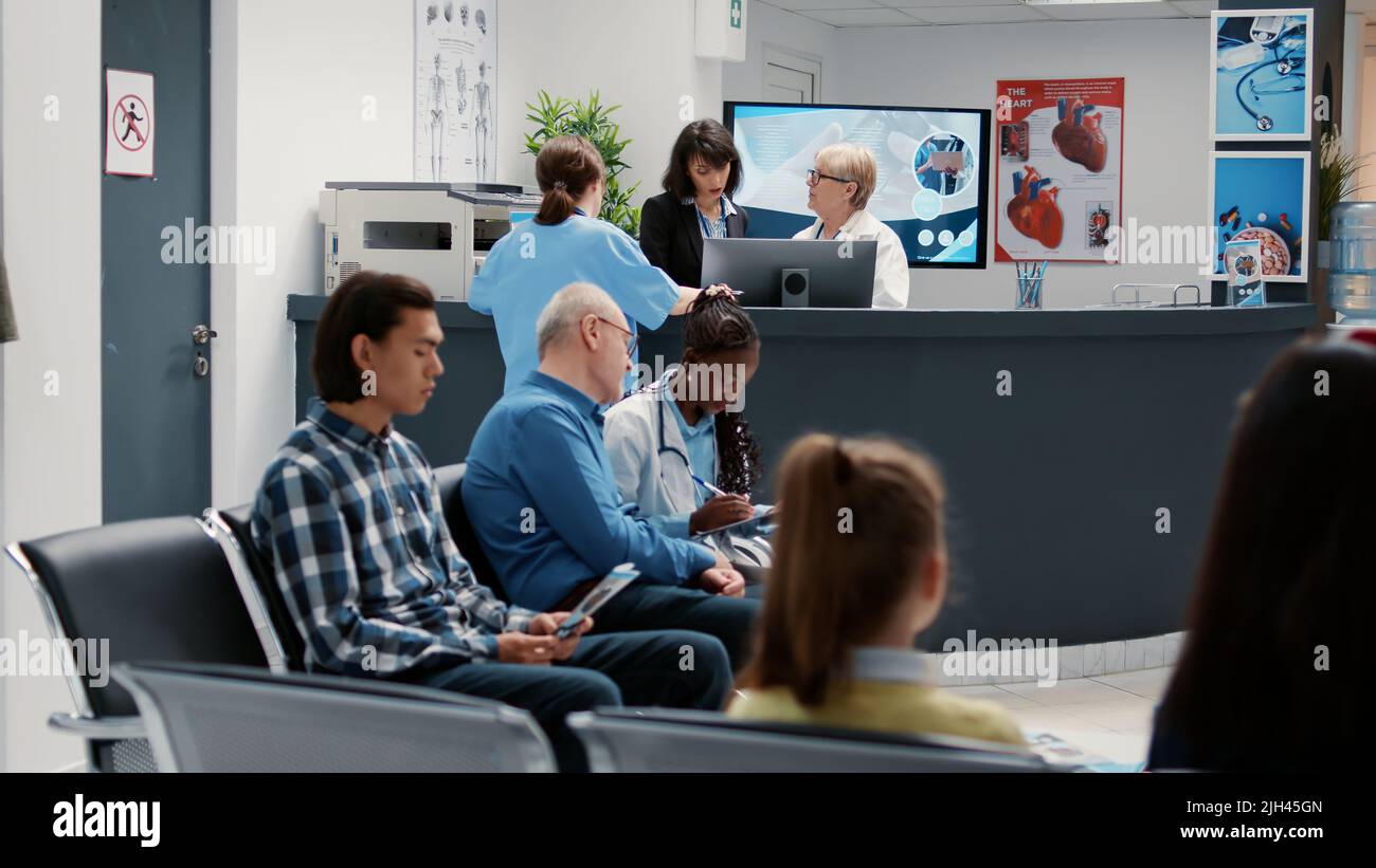 Waiting room in hospital lobby with reception counter desk, diverse ...
