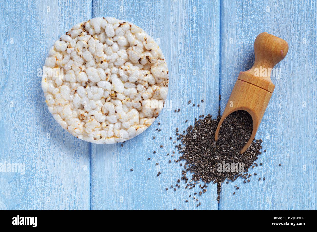Round rice cake and chia seeds on blue table, top view. Healthy food ...