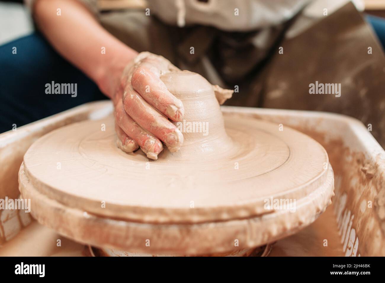 Spinning potters wheel with clay and hand Stock Photo - Alamy