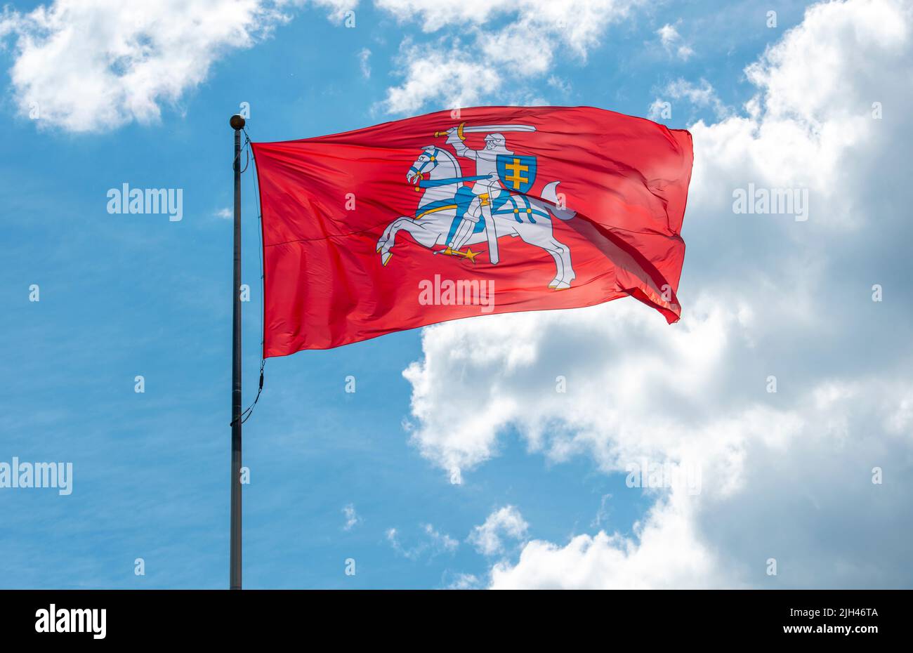 Historical state flag of Lithuania, red Vytis flag in front of blue sky ...