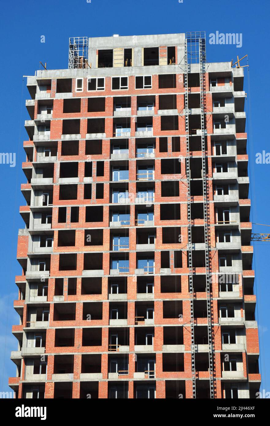 High-level brick wall building with wall construction and windows ...