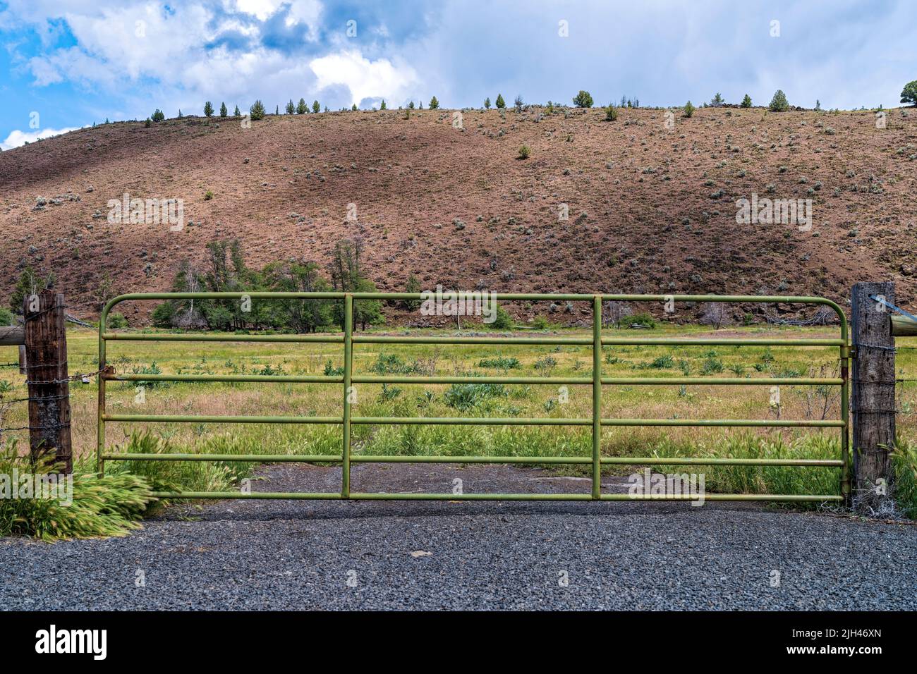Green metal gate to a farm field in the hills of central Oregon, USA ...
