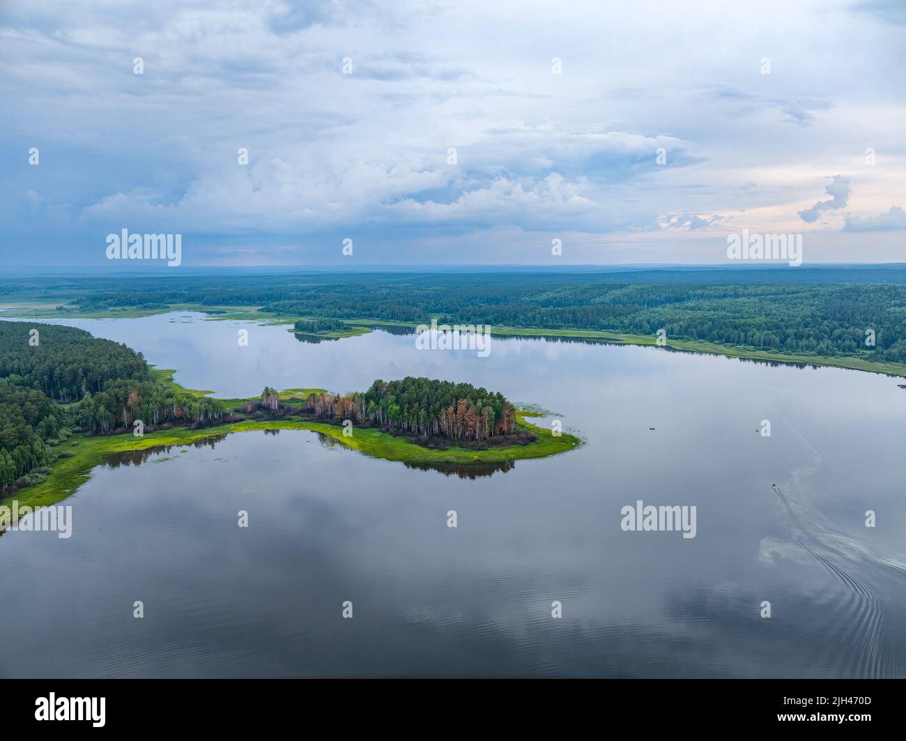 Big lake with green shores in bright sun light, aerial landscape ...