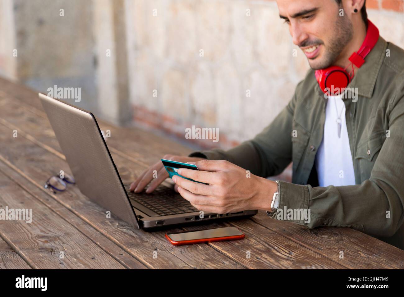 Man making purchases with his credit card using his laptop from a ...