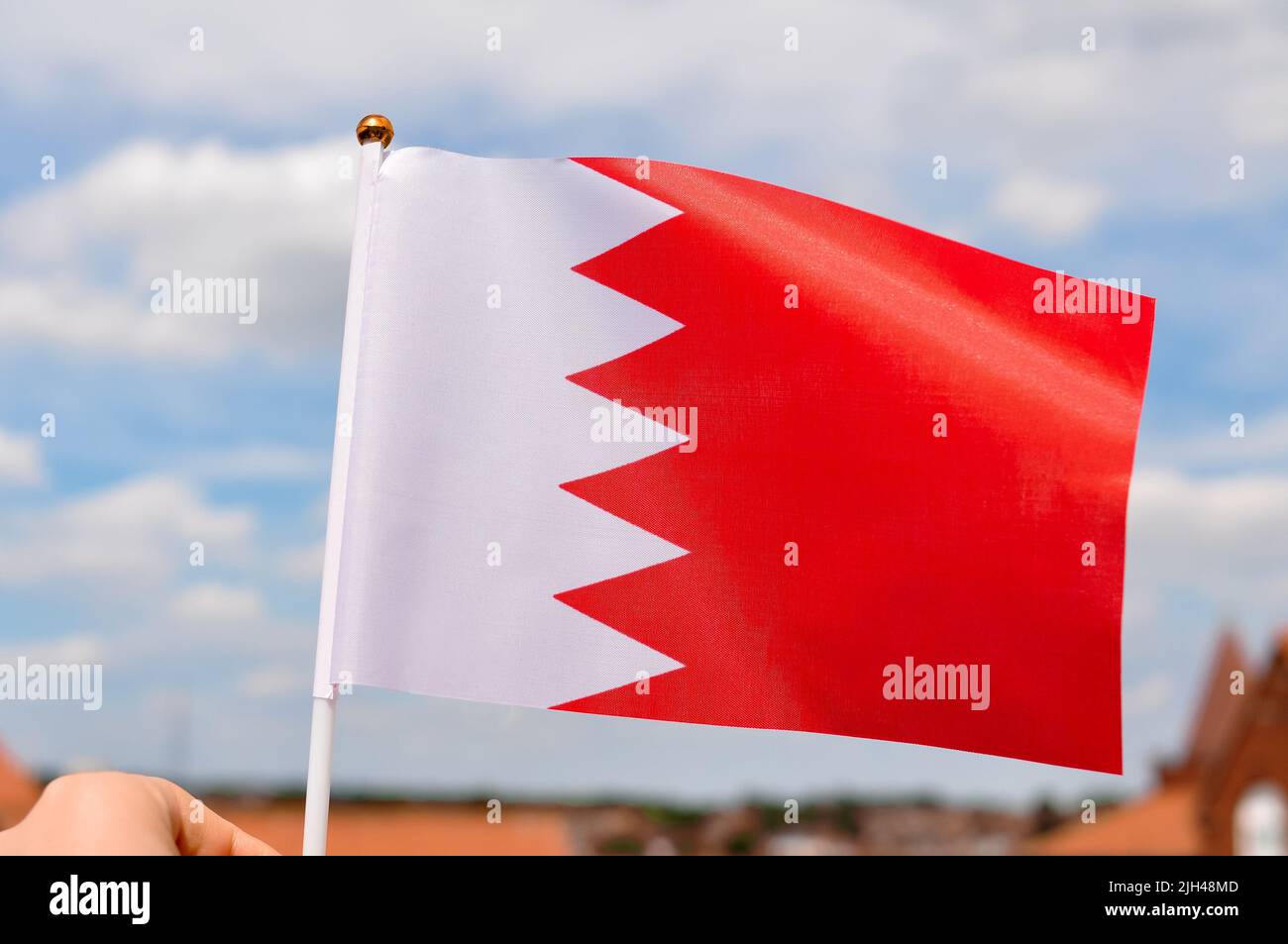 close up of national flag of bahrain on blue sky background ,red and ...