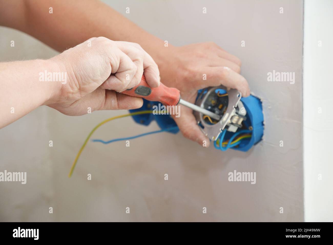 Electrican installing socket, outlet plug in new house wall Stock Photo ...
