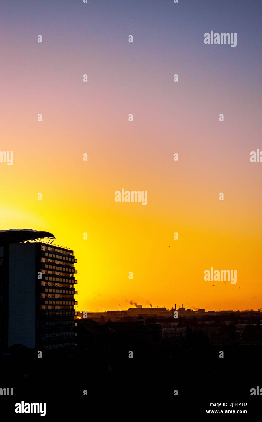 A beautiful orange sunset with modern style buildings in view, taken on ...