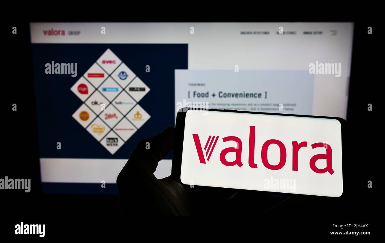 Person holding cellphone with logo of Swiss retail company Valora ...