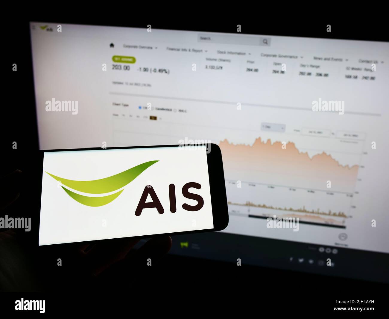 Person holding cellphone with logo of Thai company Advanced Info Service (AIS) on screen in ...