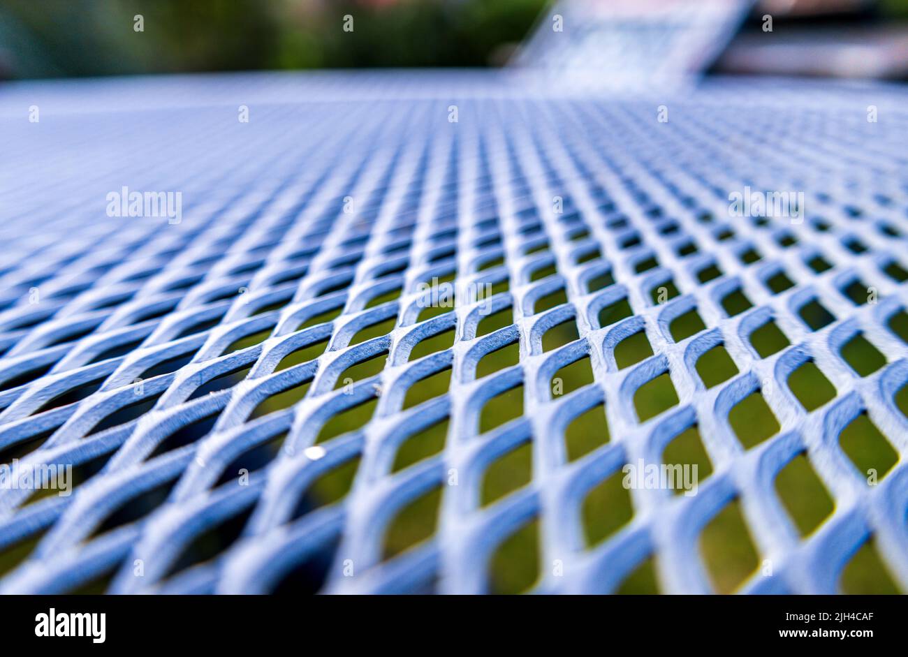 A view from the table level of an outdoor mesh metal table, in a garden ...