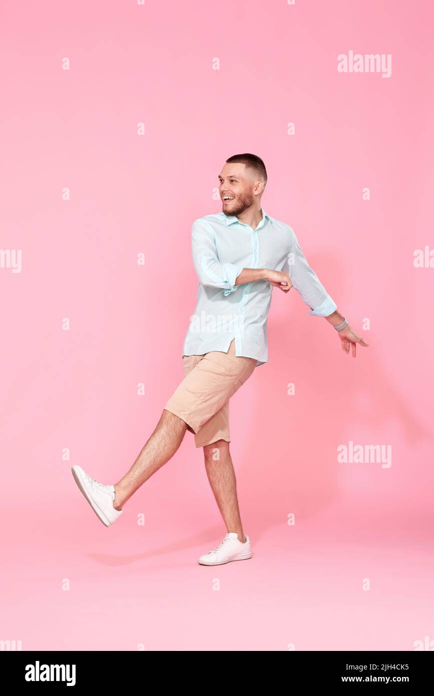 cheerful young happy man dance on pink background Stock Photo - Alamy